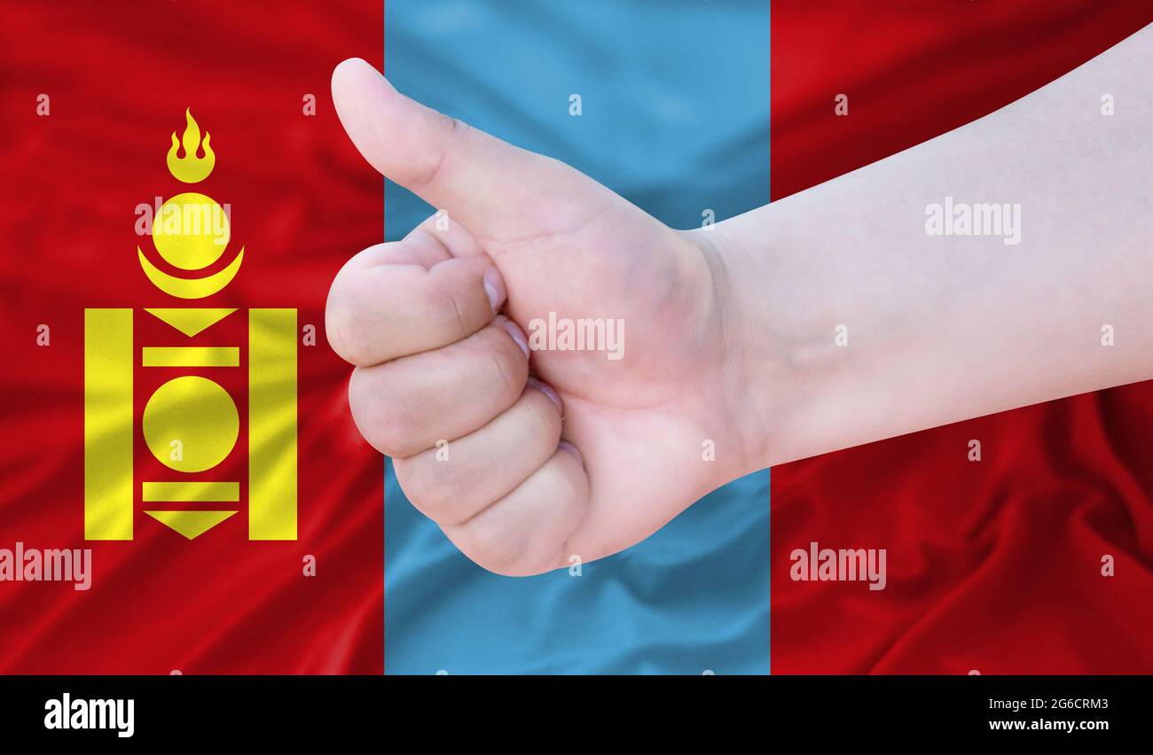Hand makes a thumbs up sign on the background of the flag of Mongolia ...