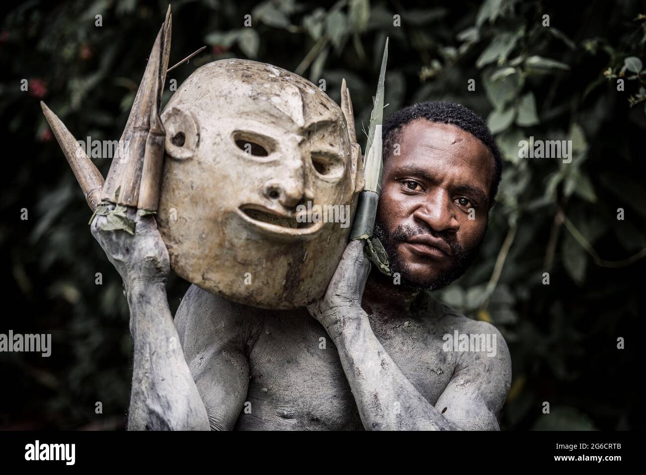 A Mudman holding up his mud-covered mask. PAPUA NEW GUINEA: THIS ...