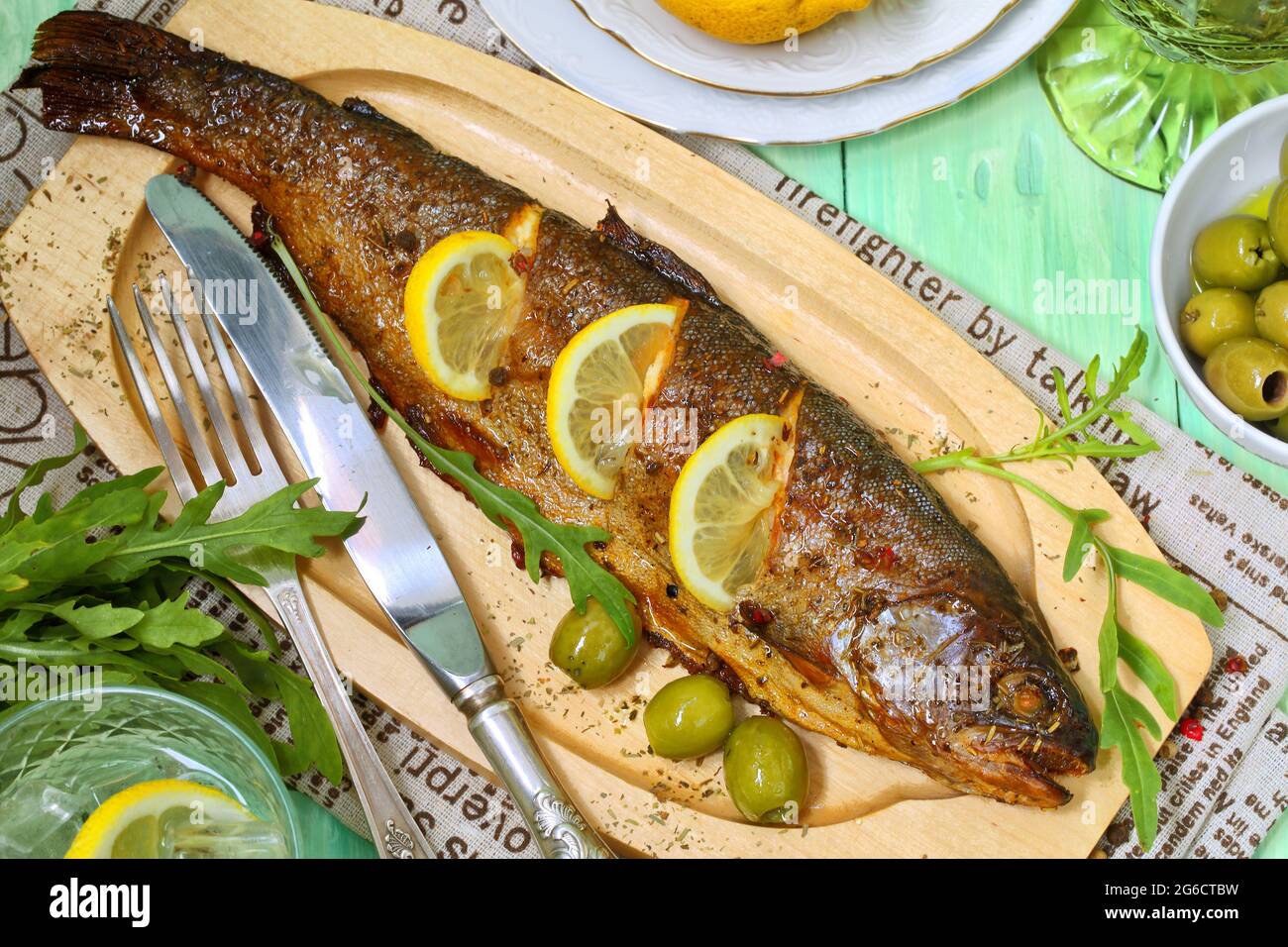 Baked trout in Italian herbs with lemon and olives Stock Photo - Alamy