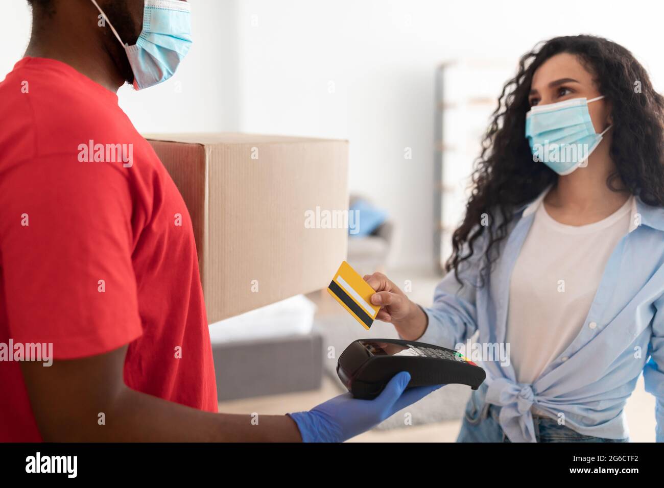 Black man holding POS machine lady paying with debit card Stock Photo ...
