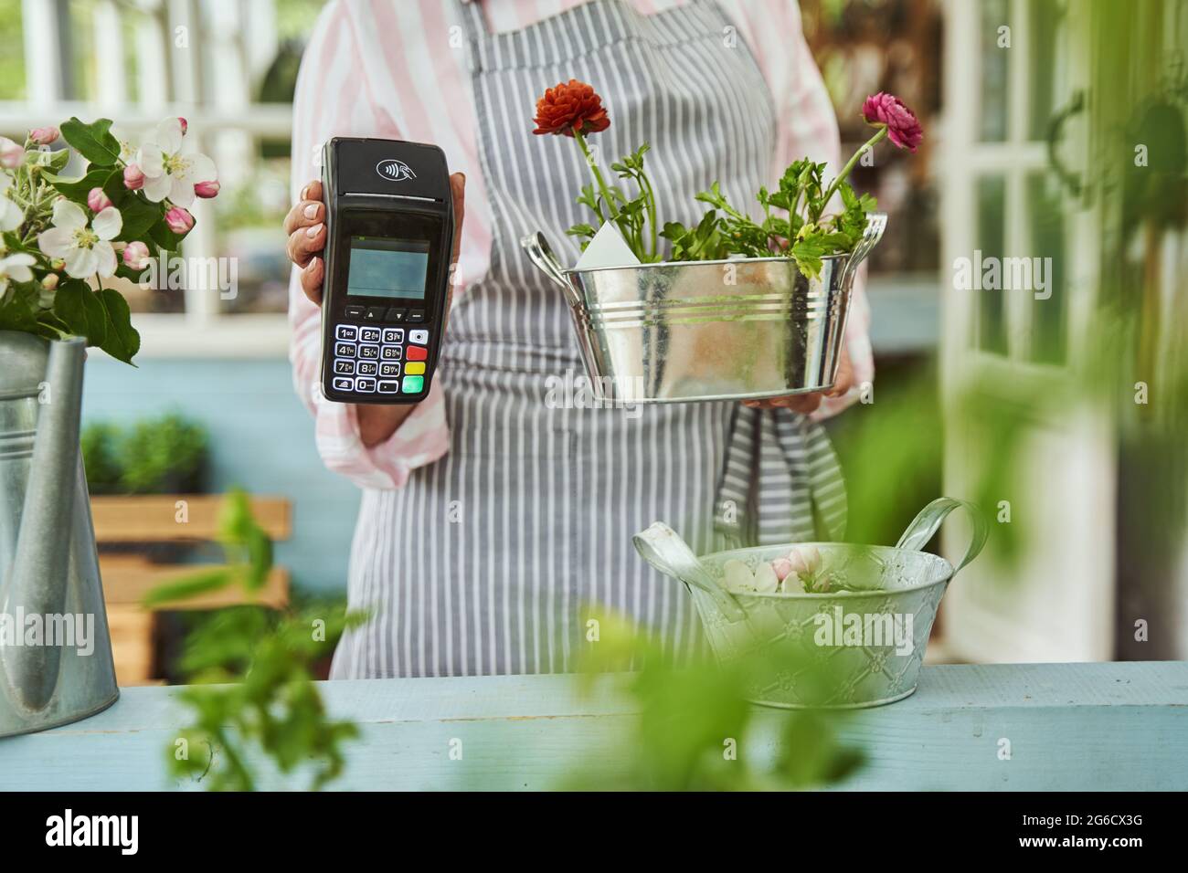 Female florist using pos terminal for sales Stock Photo - Alamy