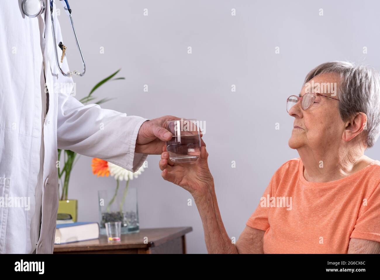 Doctor giving a glass of water to an elderly patient Stock Photo - Alamy
