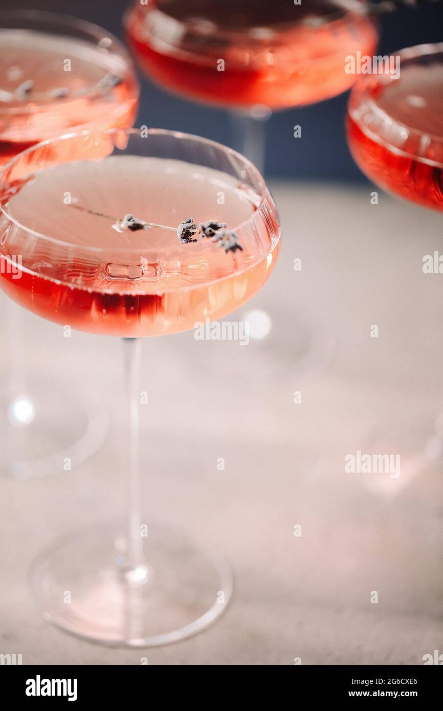 Set of glass goblets with champagne and flowers placed on table in ...