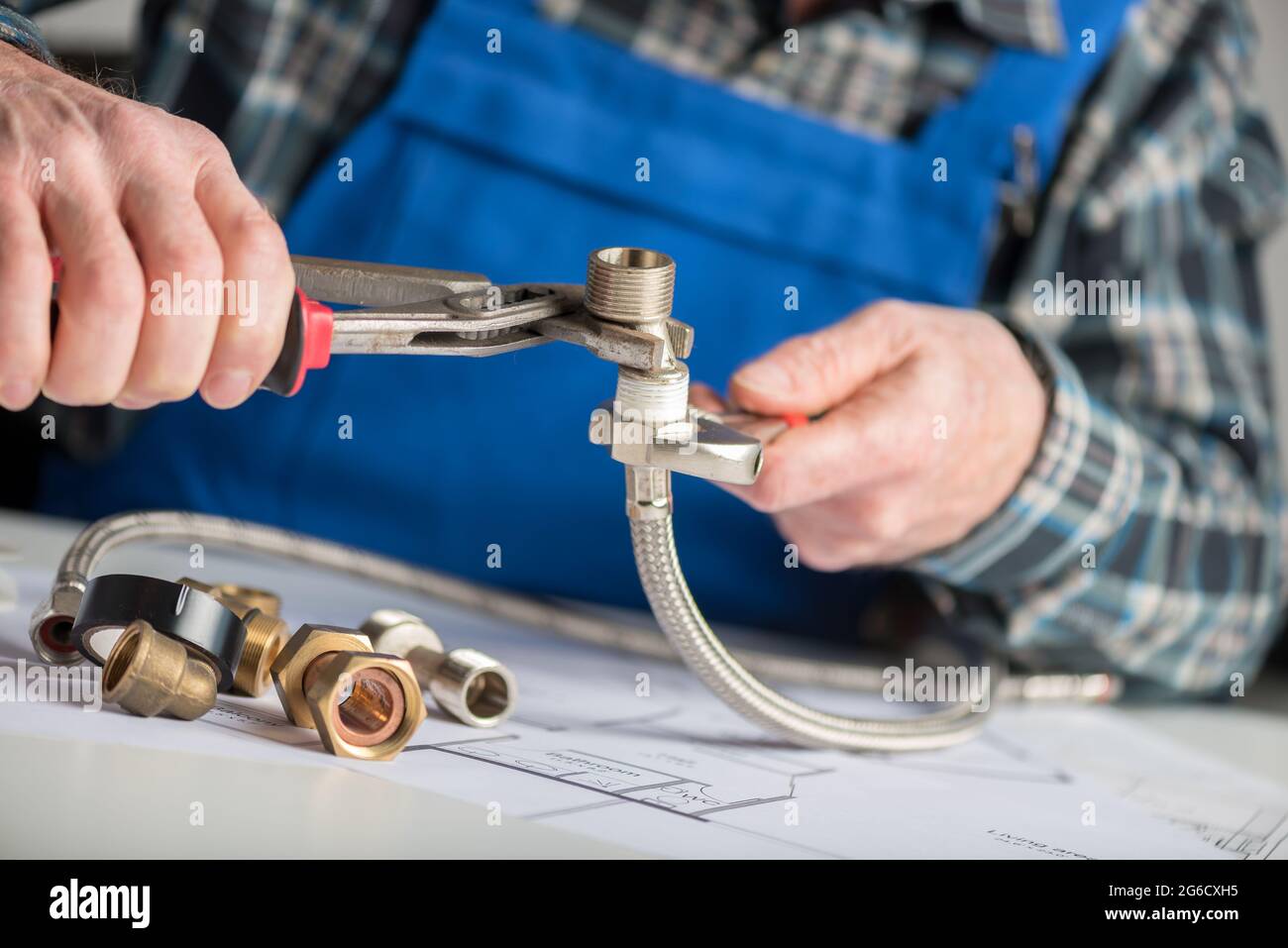 Plumber screwing a plumbing fitting on a pipe Stock Photo - Alamy