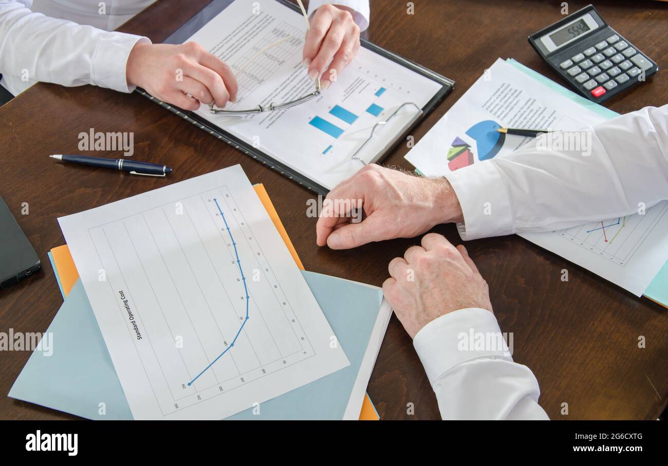 Two business people analyzing charts Stock Photo - Alamy