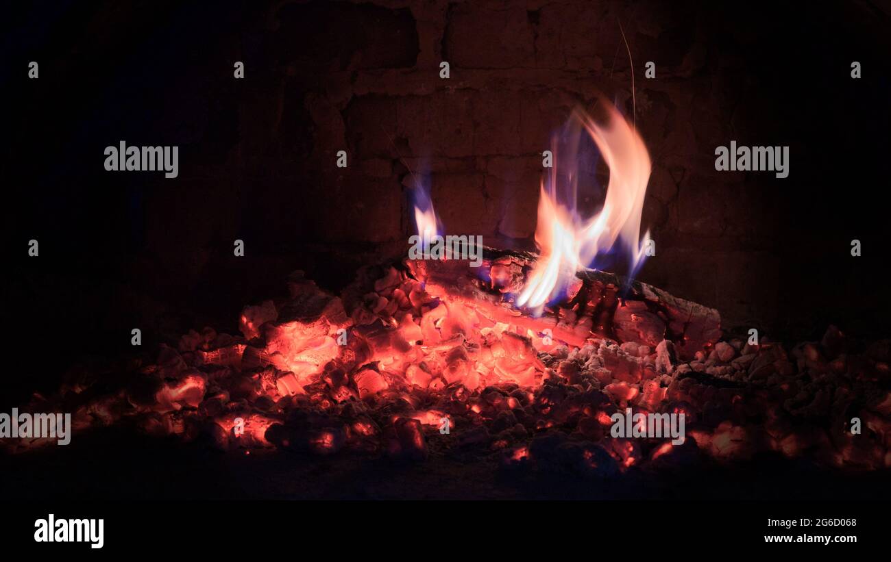 Logs of firewood burn out in the oven. Coals and flames in the ...