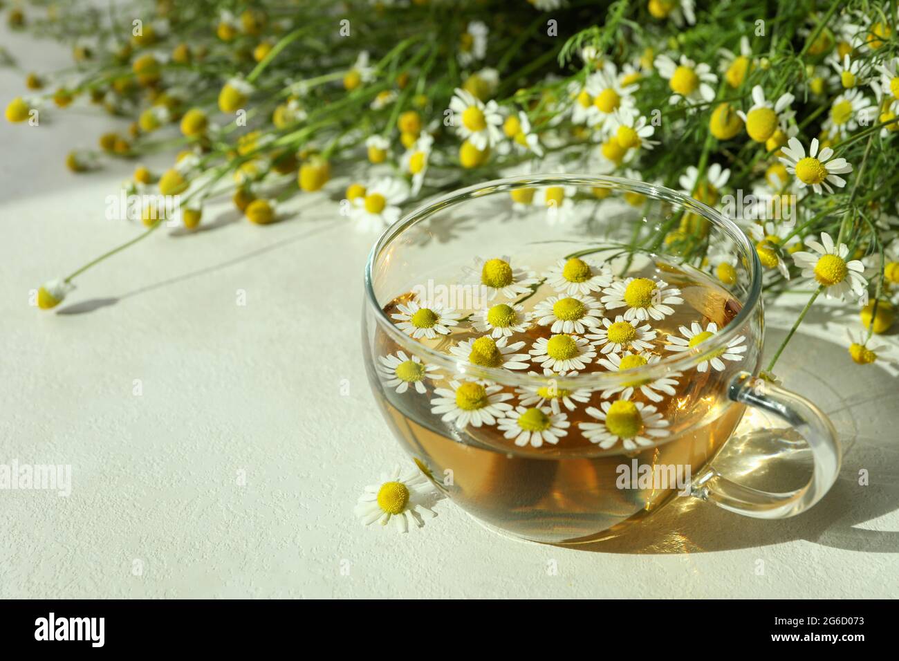 Cup of chamomile tea on white textured table Stock Photo - Alamy