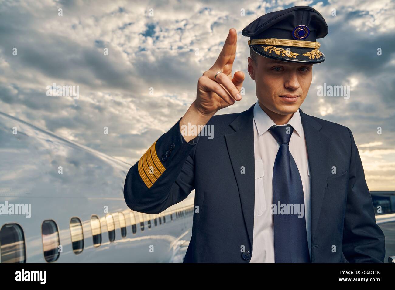Young airline pilot showing his readiness for take-off Stock Photo - Alamy