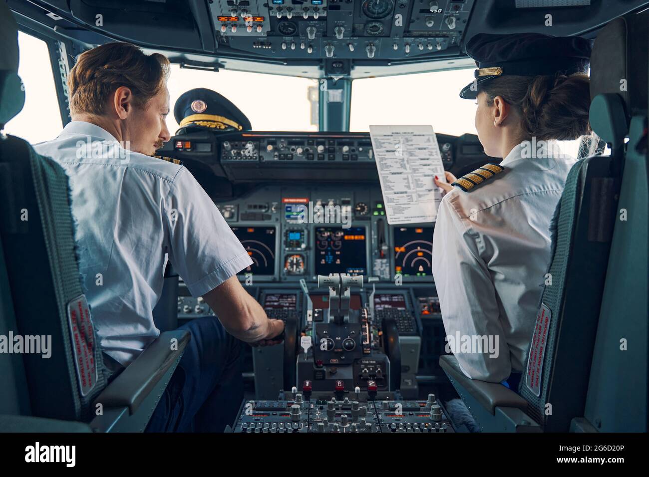 Pilot and female first officer seated in the flight deck Stock Photo ...