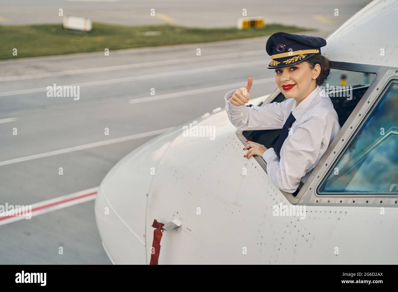 Airline pilot showing her readiness for take-off Stock Photo - Alamy