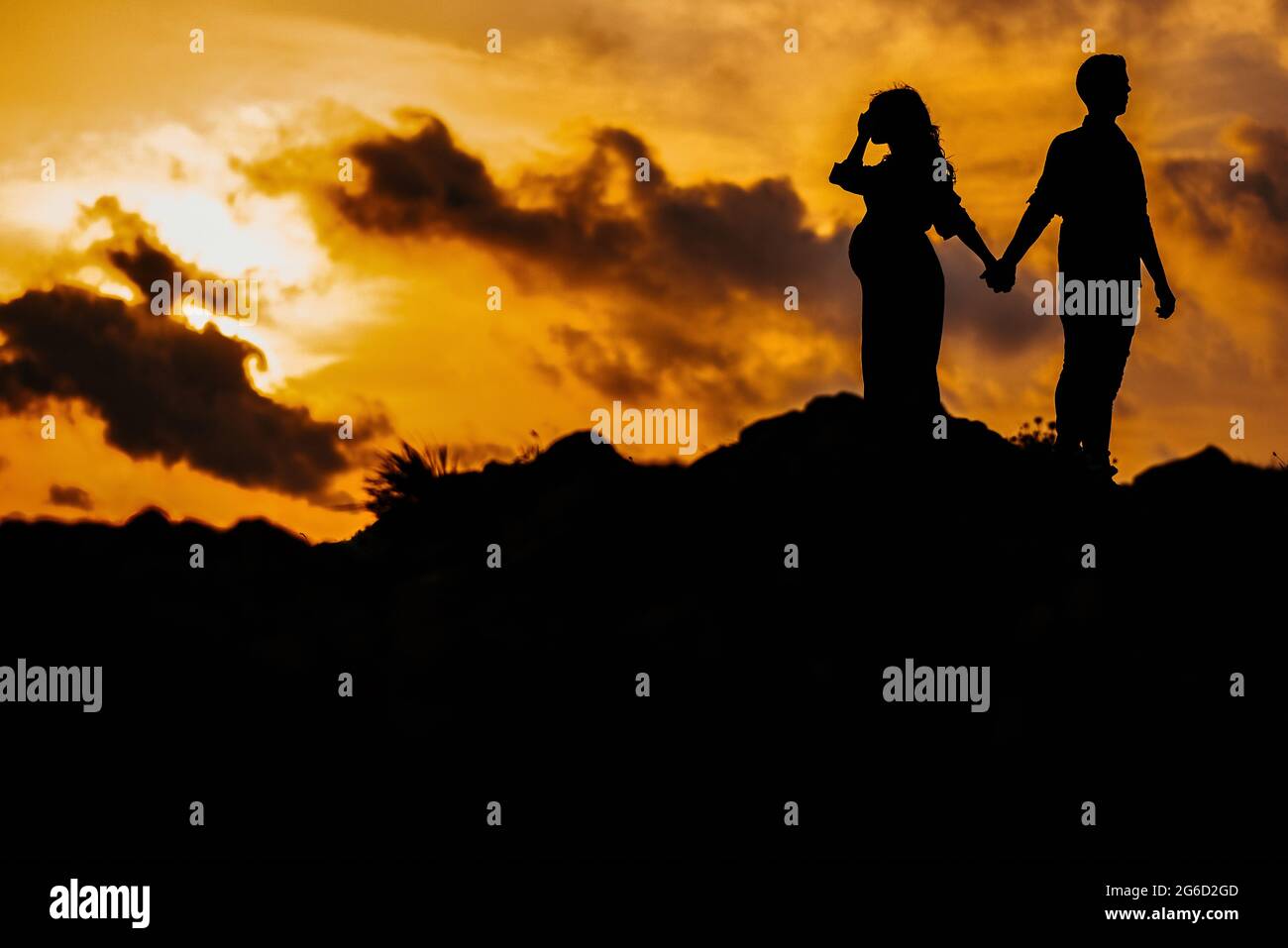 Low angle side view silhouettes of unrecognizable couple expecting baby ...