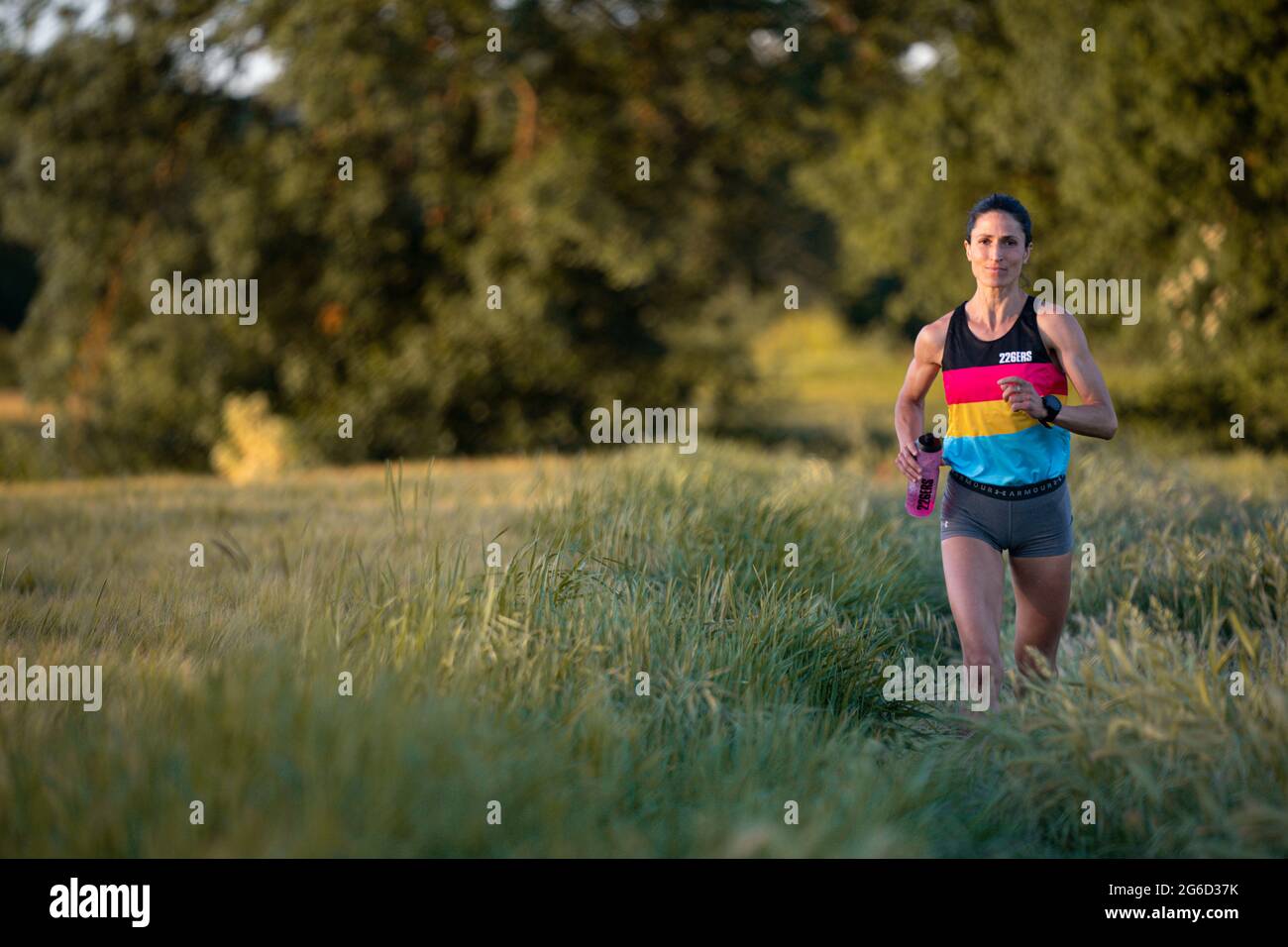 Athlete girl running on a road in the middle of nature Stock Photo - Alamy