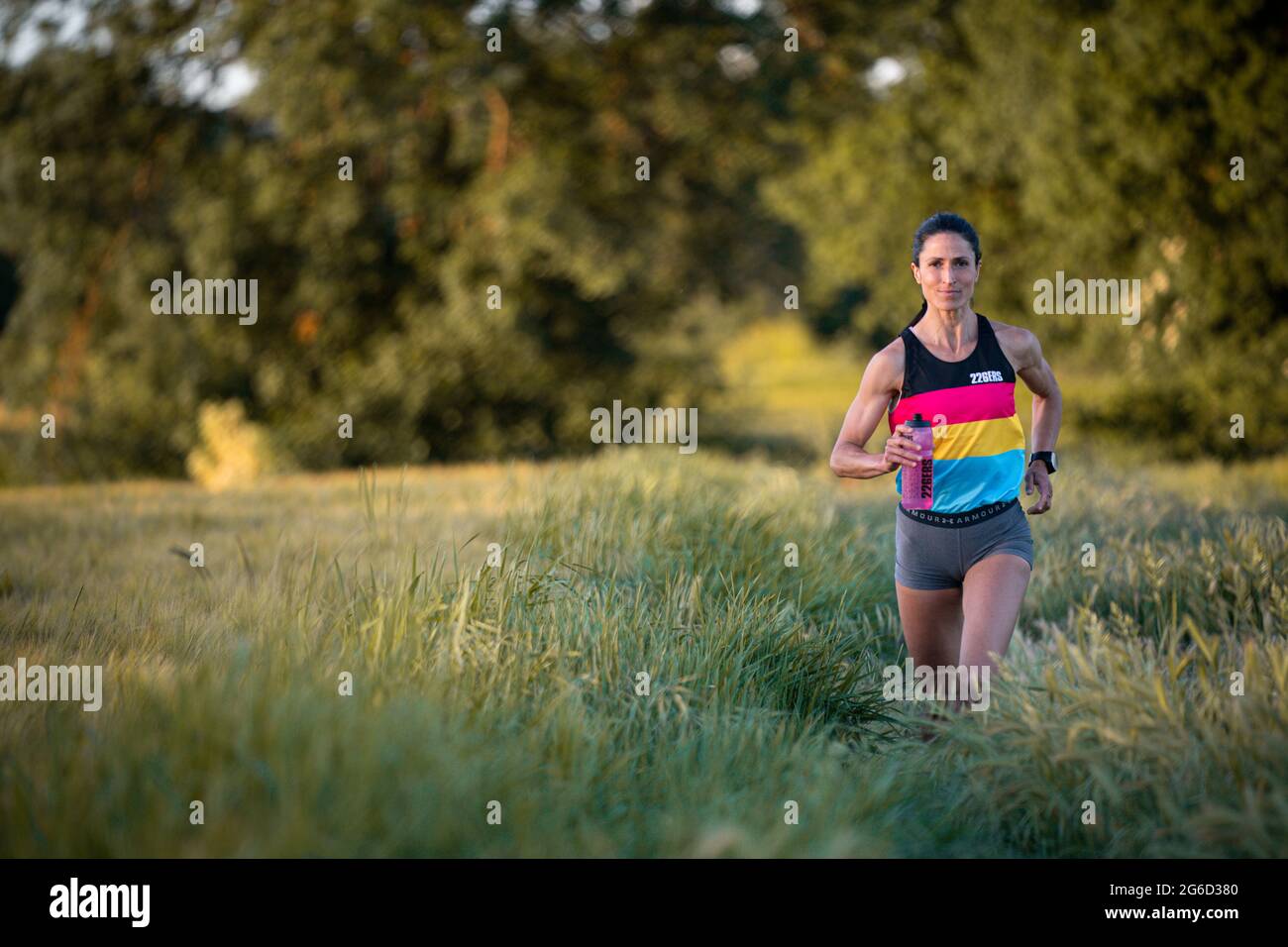Athlete girl running on a road in the middle of nature Stock Photo - Alamy