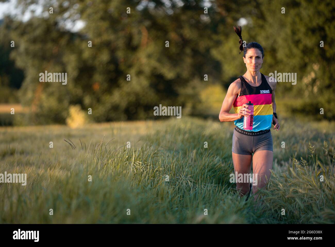 Athlete girl running on a road in the middle of nature Stock Photo - Alamy