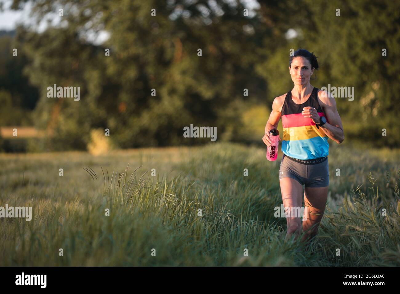 Athlete girl running on a road in the middle of nature Stock Photo - Alamy