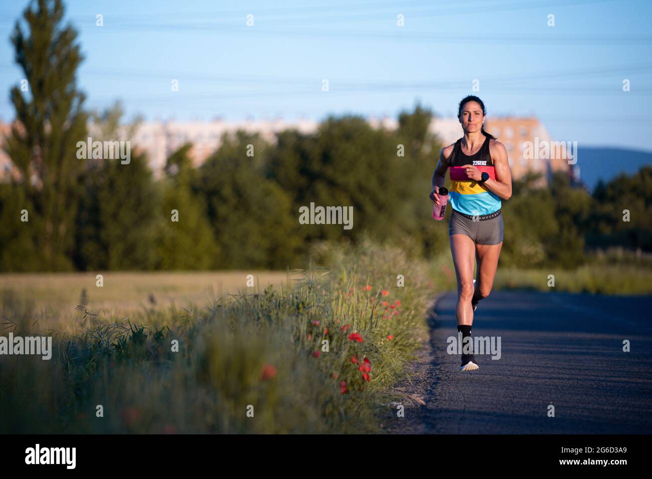 Athlete girl running on a road in the middle of nature Stock Photo - Alamy