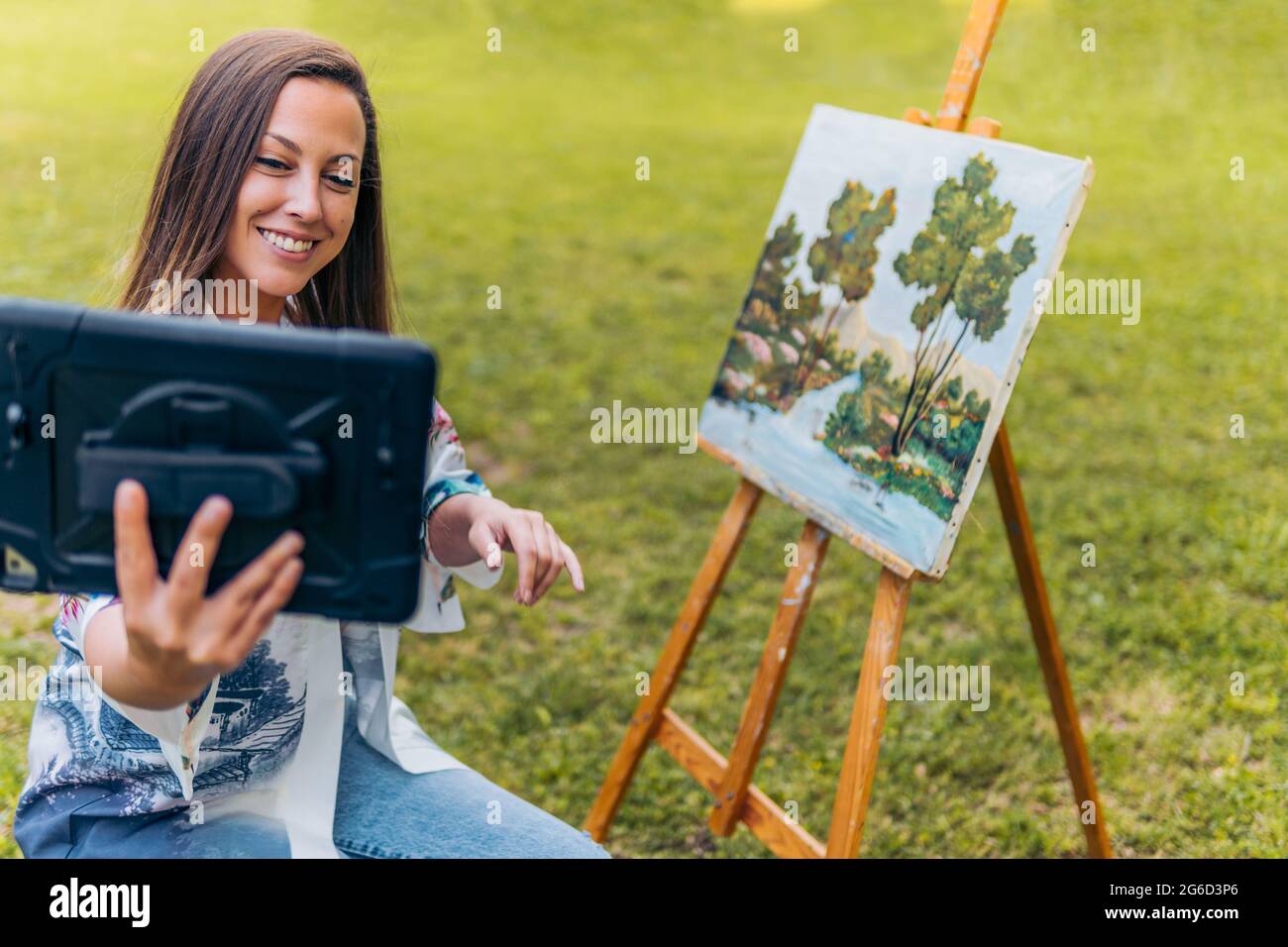 Woman making a video call to show a paint outdoors Stock Photo - Alamy