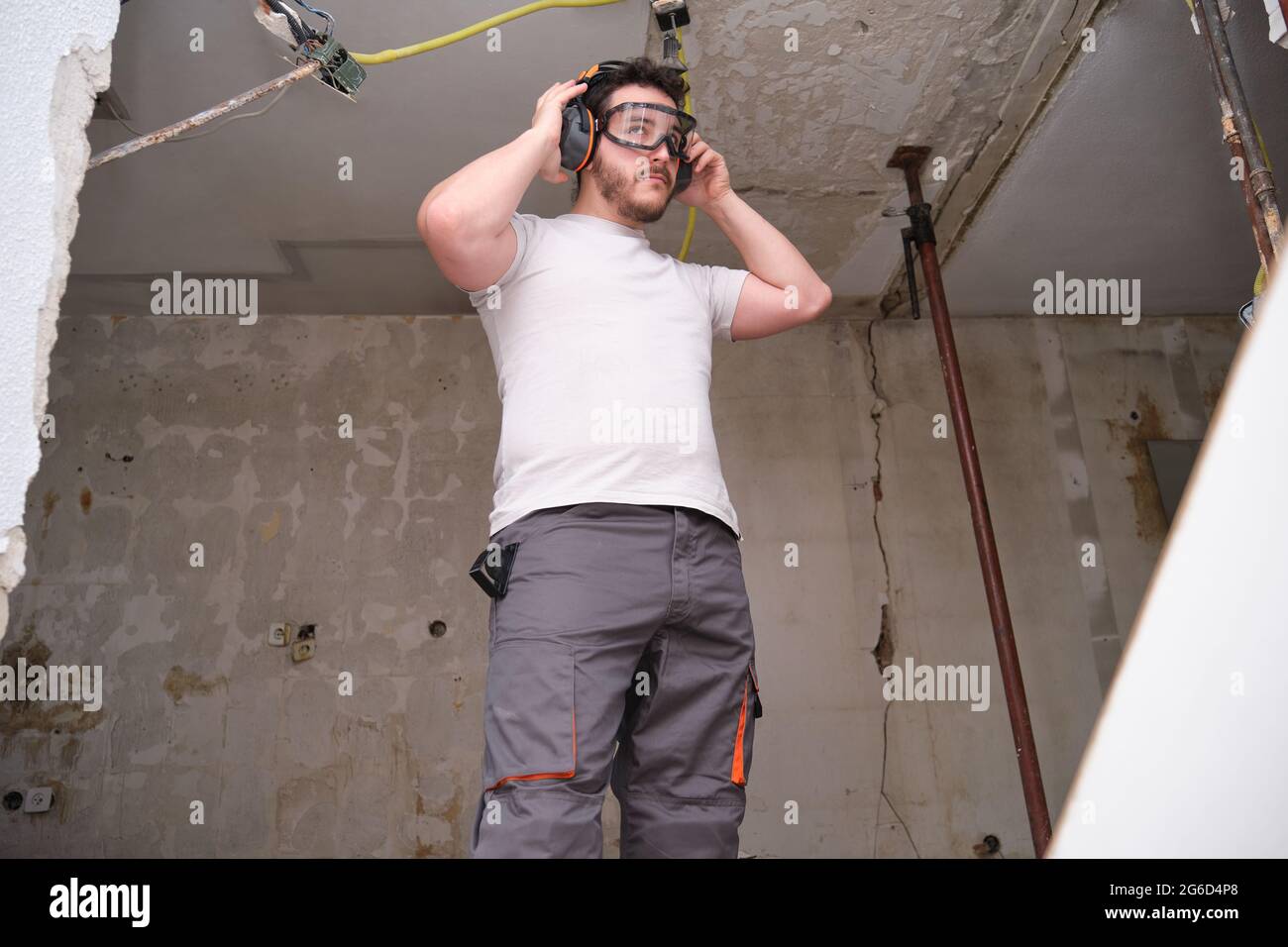 Young Builder Wearing Hearing Protection And Safety Glasses At A