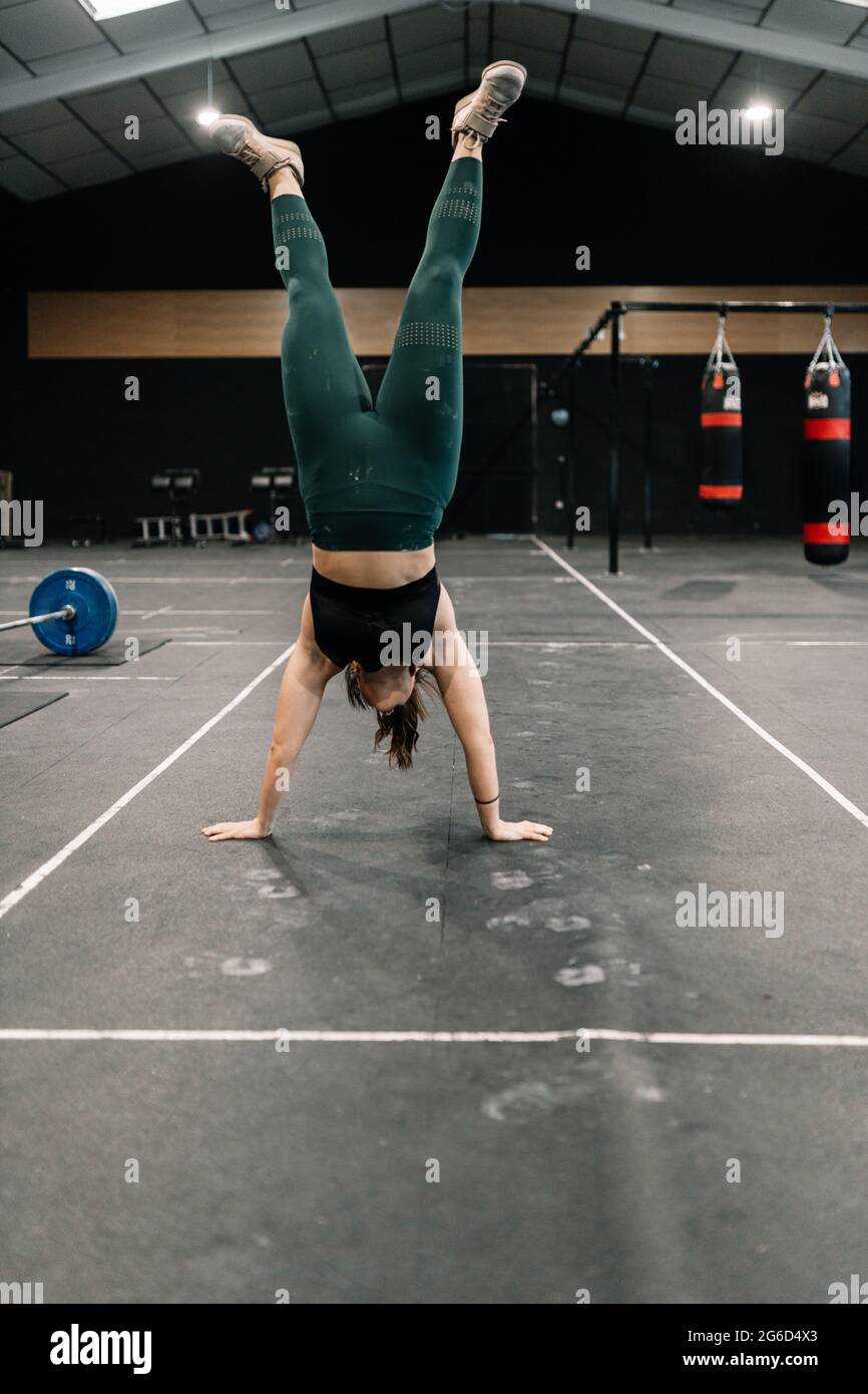 Young woman training on floor in a gym practicing handstand walk Stock ...