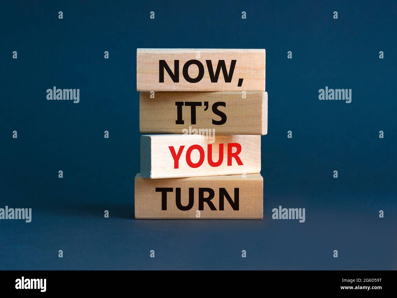 Now, it's your turn symbol. Wooden blocks form the words 'now, it's ...