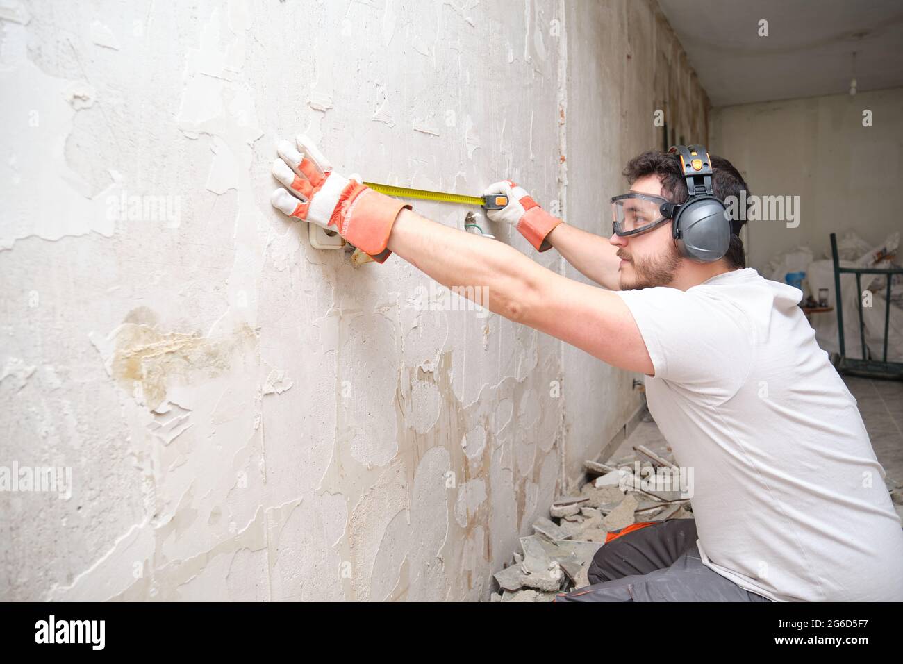 Builder man using a measuring tape at the construction site ...