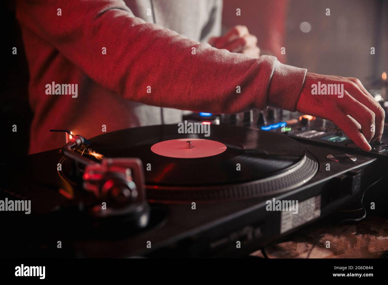 Side view of crop male DJ mixing music on controller during concert in ...