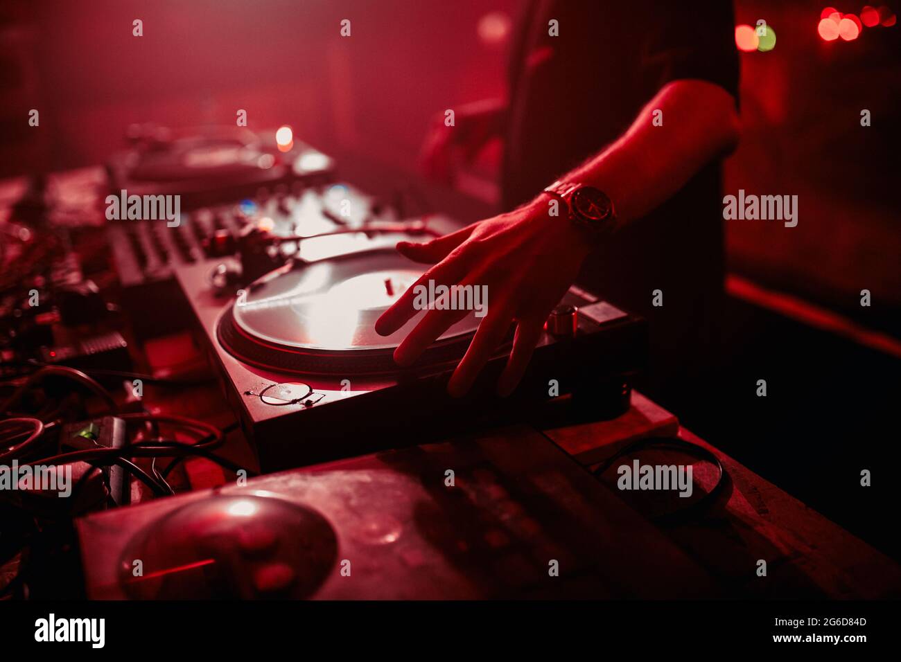 Side view of crop male DJ mixing music on controller during concert in ...