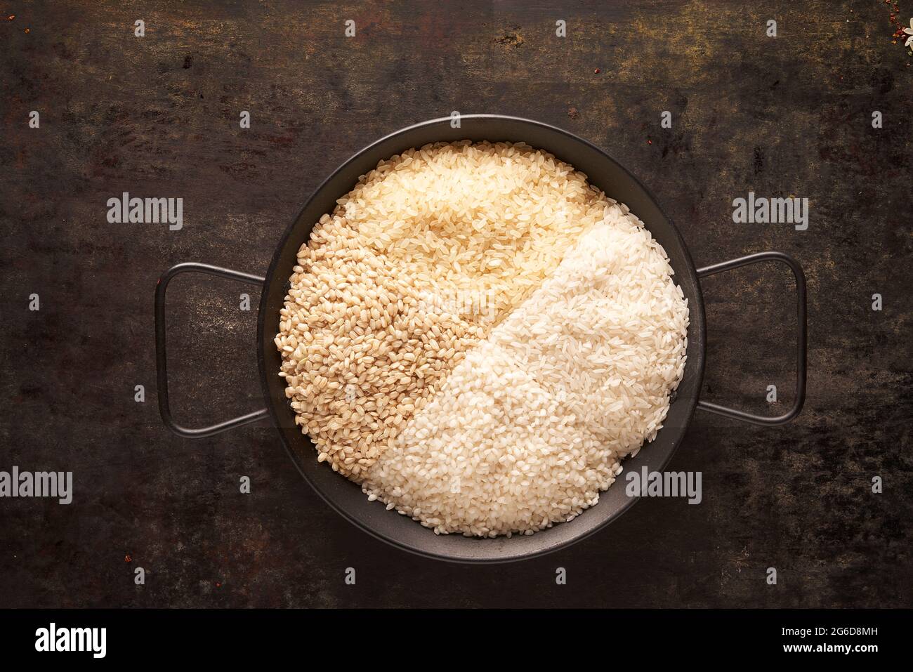 From above of bowl with assorted types of dried rice on black ...