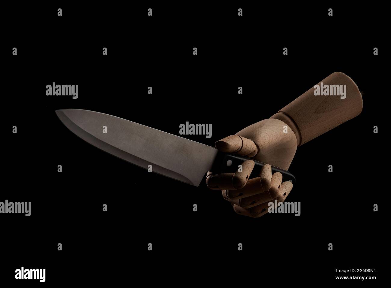 Sharp knife in wooden hand in studio on black background demonstrating ...