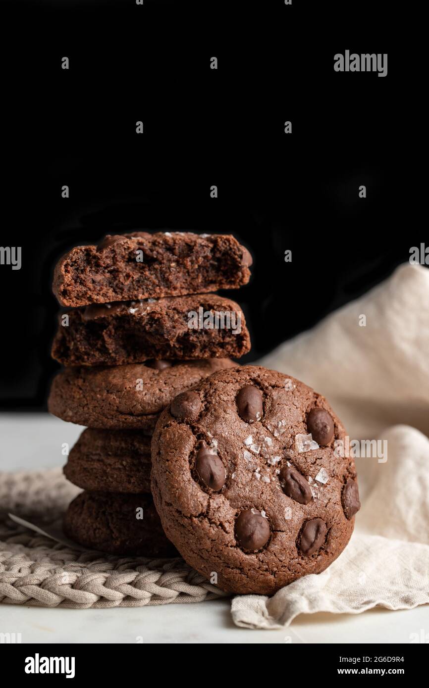 Pile of chocolate rye cookies placed on wicker plate near napkin on ...