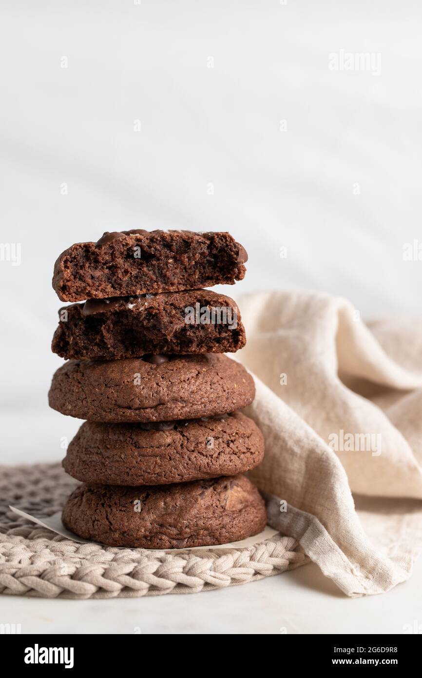 Pile of chocolate rye cookies placed on wicker plate near napkin on ...