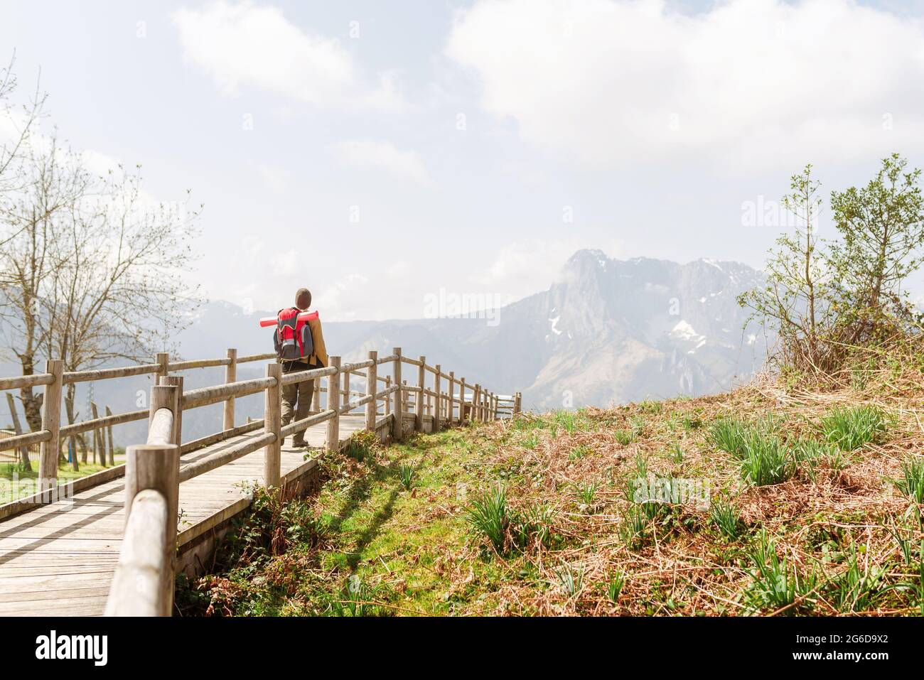 Back view of unrecognizable explorer with backpack walking on wooden ...