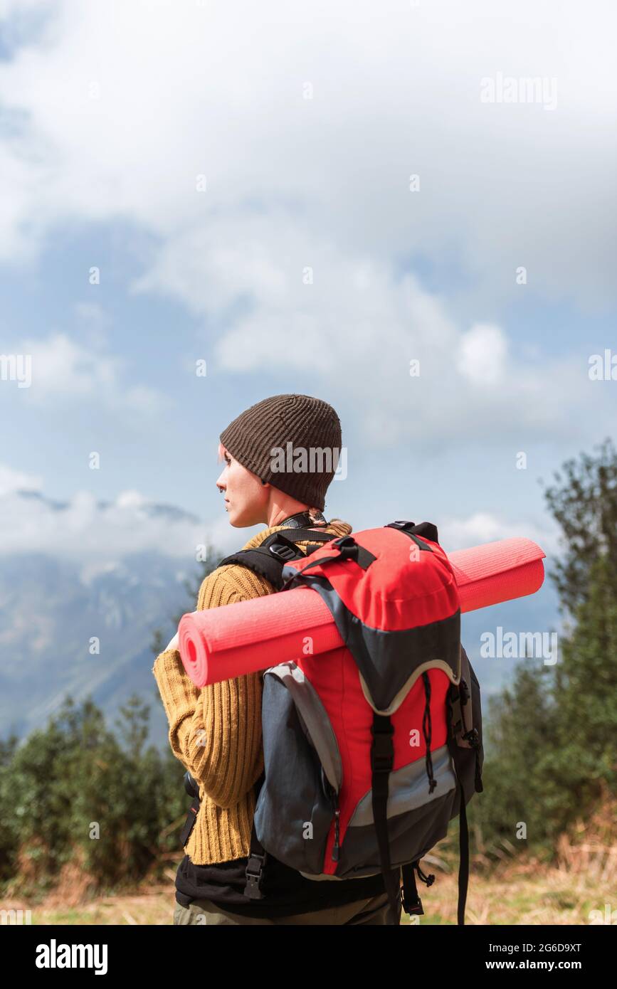 Back view of explorer with backpack standing enjoying freedom while ...