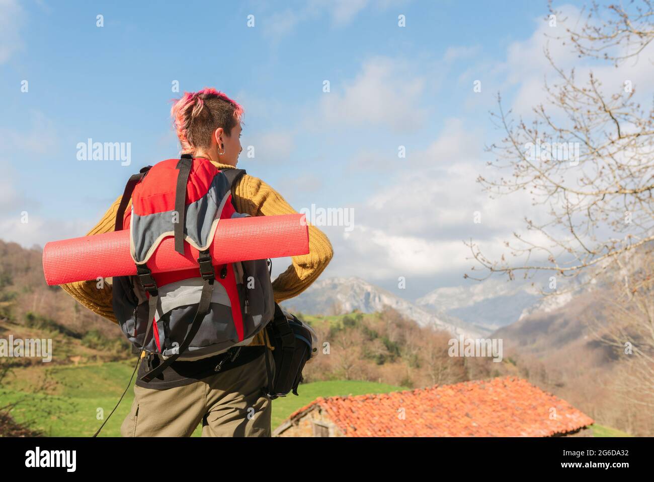 Back view of pensive female traveler with backpack standing in ...