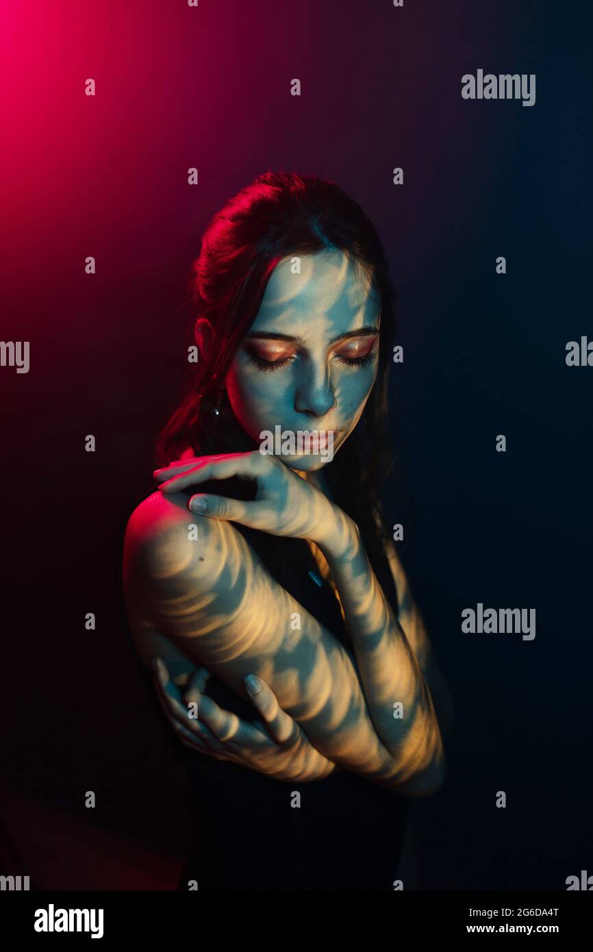 Fashionable young female model with light projection in shape of ...