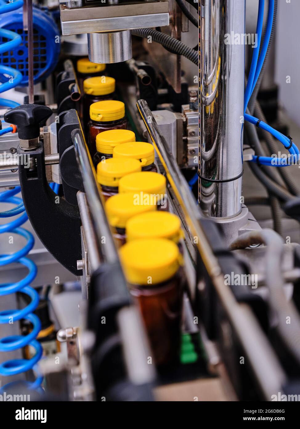 From above of modern pharmaceutical machine capping plastic bottles ...