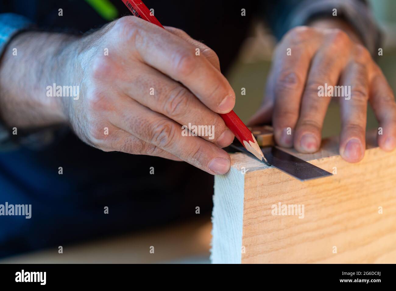 Crop professional woodworker with pencil and measuring tool making ...