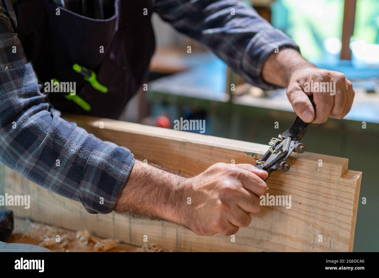 Crop unrecognizable skilled male joiner smoothing timber plank with ...