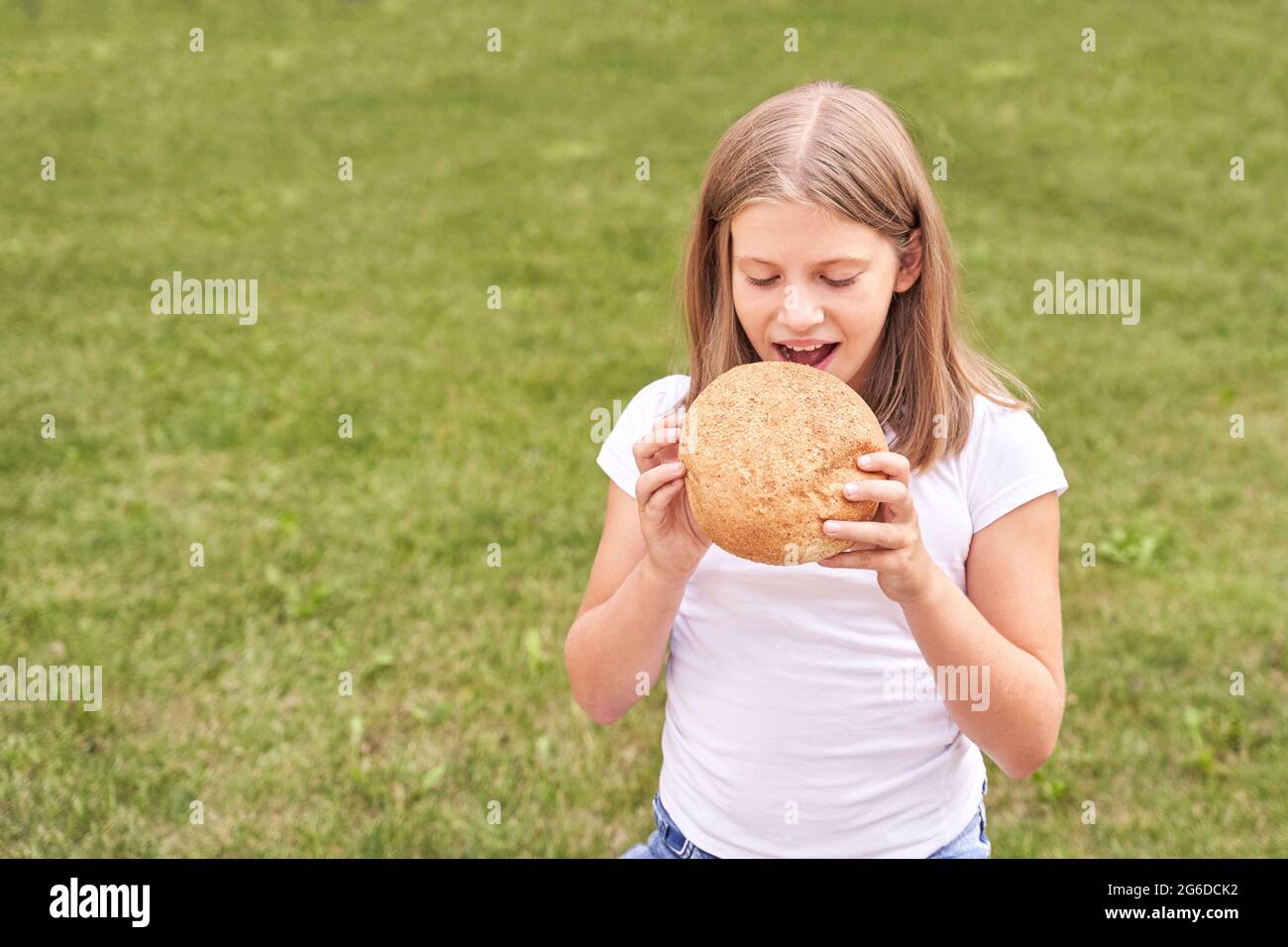 Child holds and bite round bread. Healthy food Stock Photo - Alamy