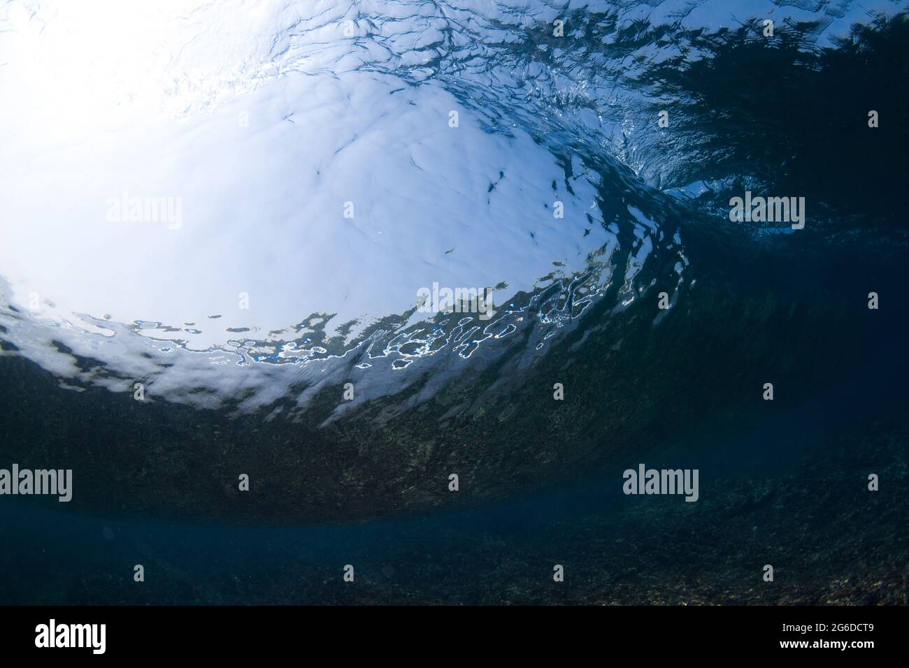 Underwater view of rough rocky bottom of sea with blue water at daytime ...