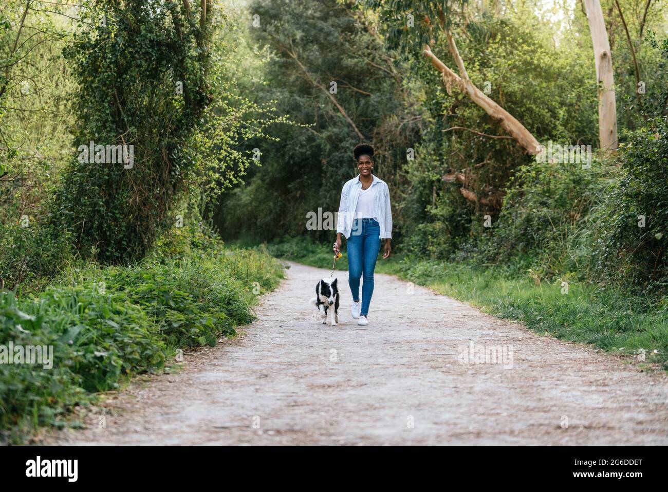 Full body of positive young African American female owner walking with ...