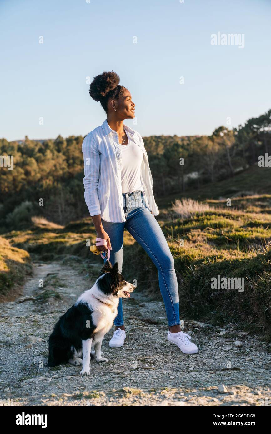 Full body side view of happy ethnic Woman with Border Collie dog ...