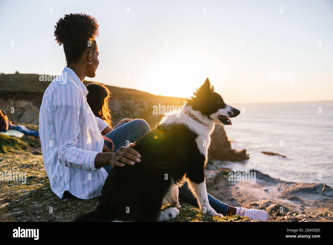 Side view of young African American female owner with Border Collie dog ...