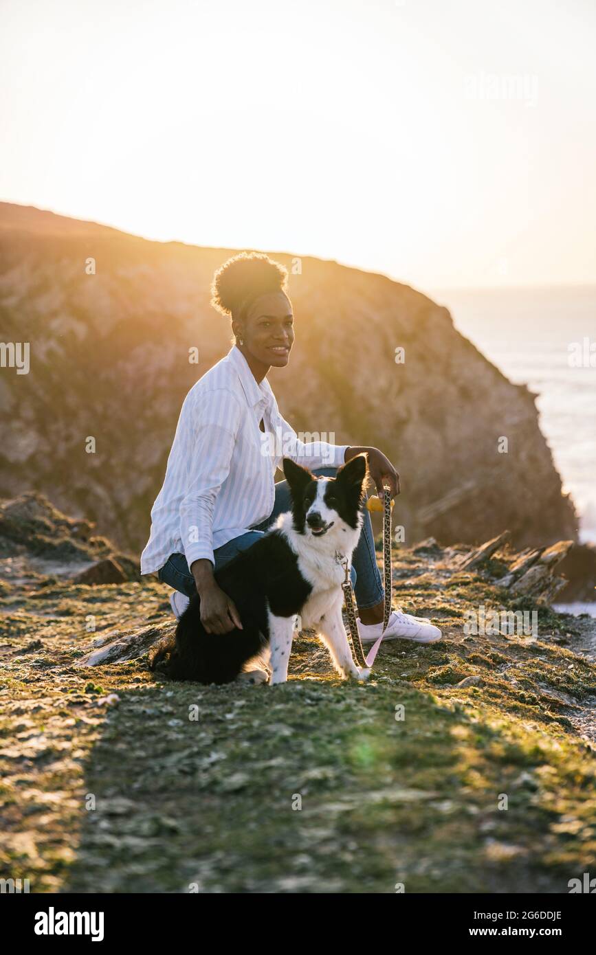 Side view of young African American female owner with Border Collie dog ...