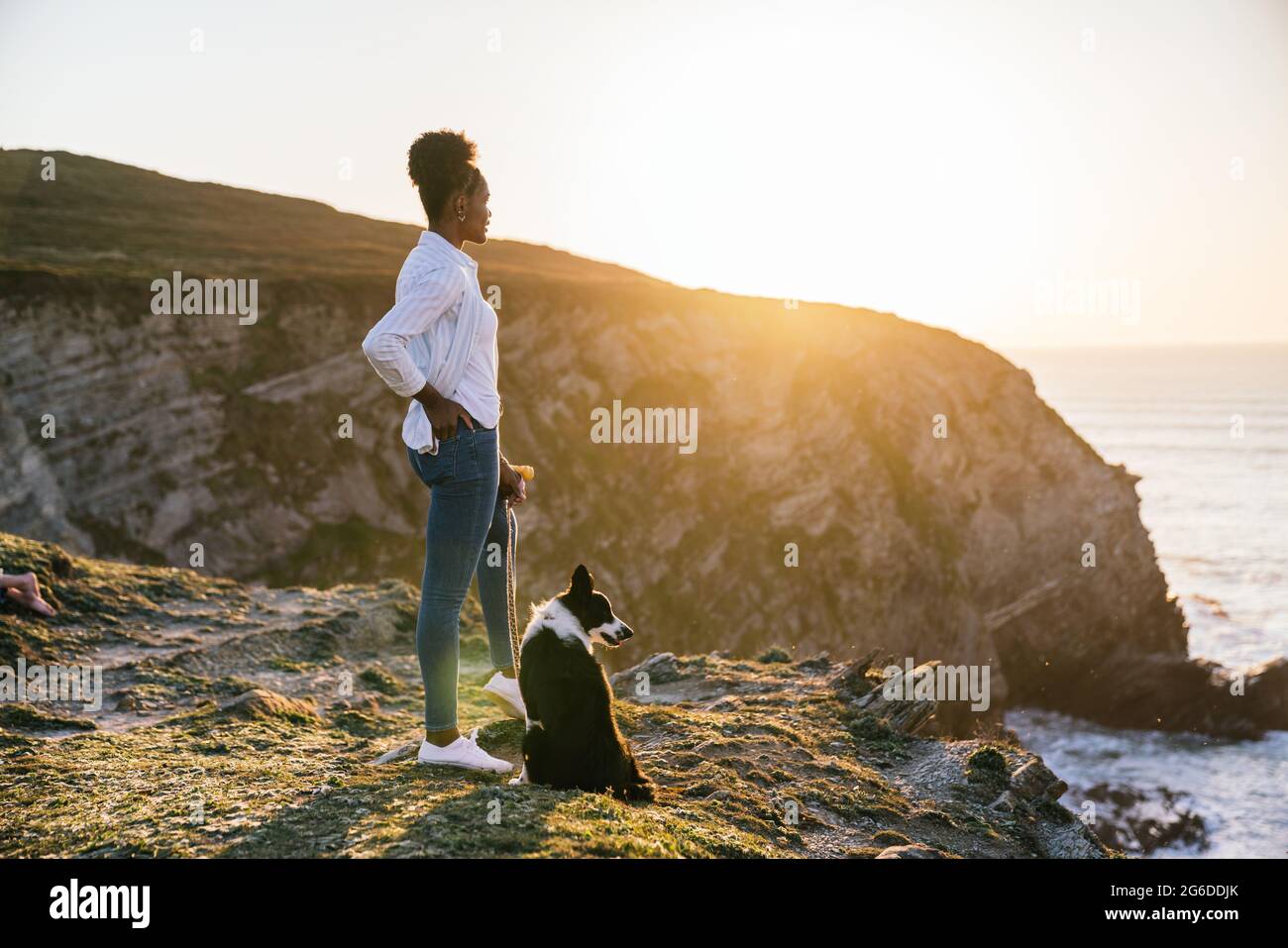 Side view of young African American female owner with Border Collie dog ...