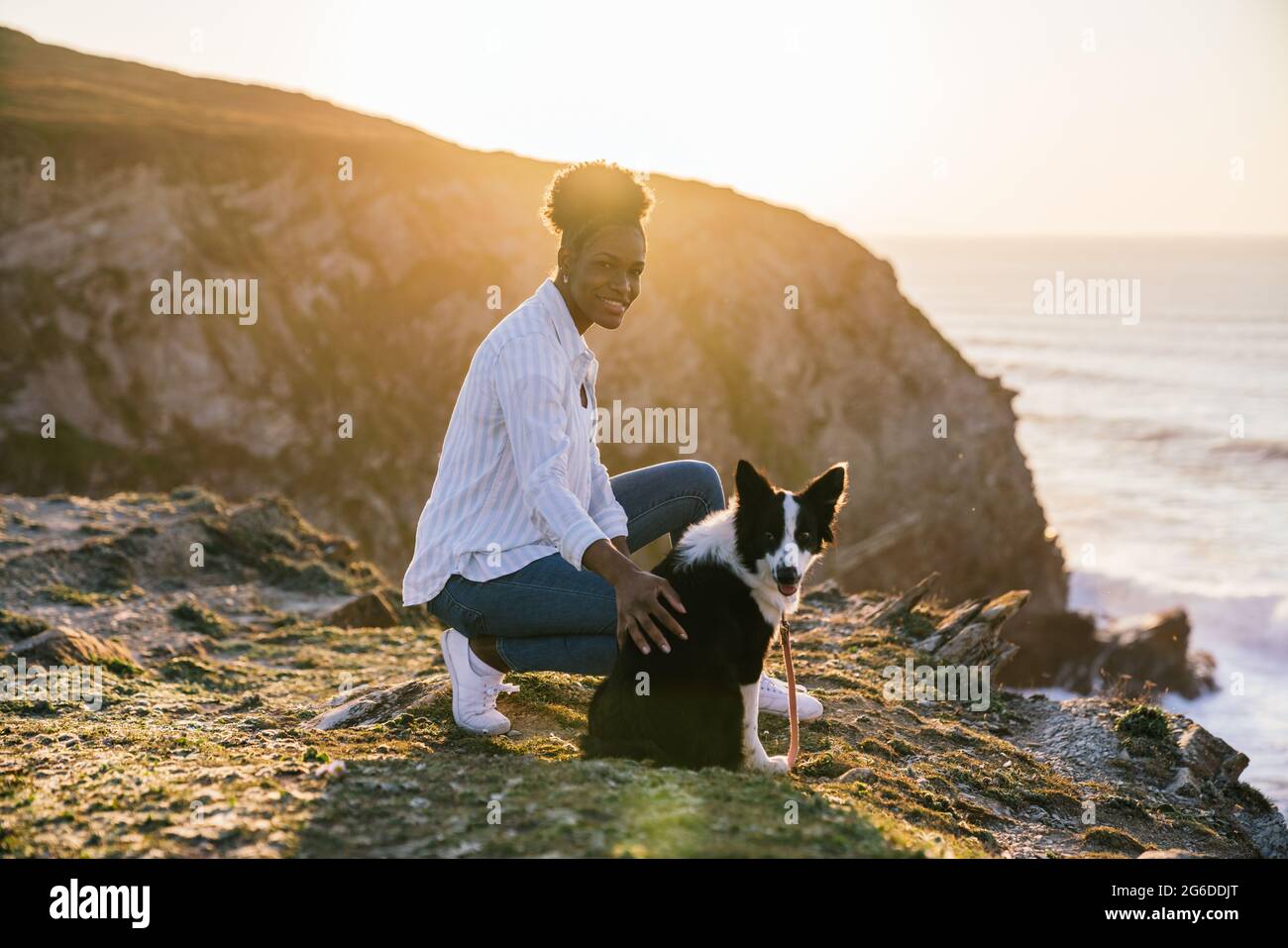 Side view of young African American female owner with Border Collie dog ...