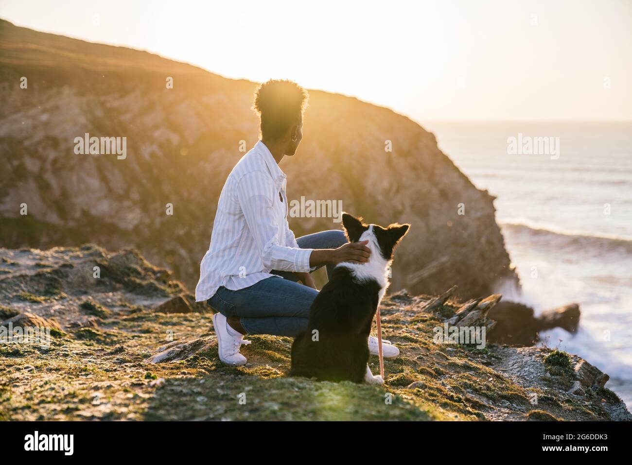 Side view of young African American female owner with Border Collie dog ...