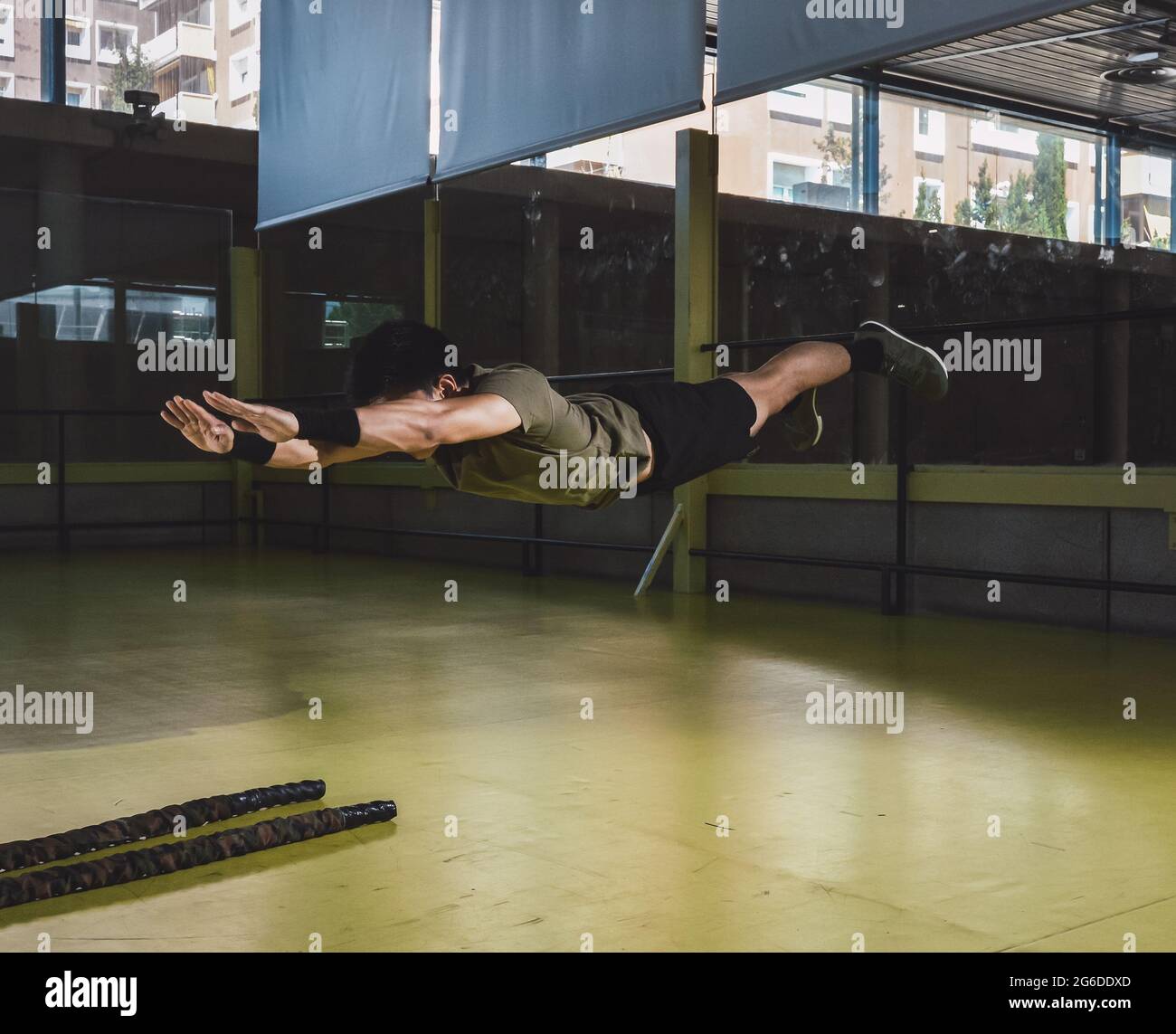 Focused Asian boy training with battle rope in modern crossfit gym ...