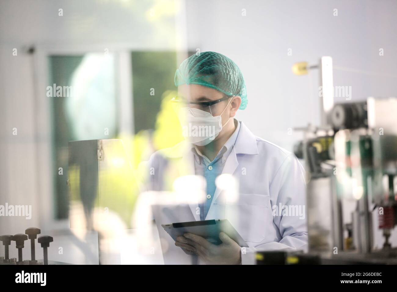 Quality control worker analyzing manufacturing machine in laboratory ...