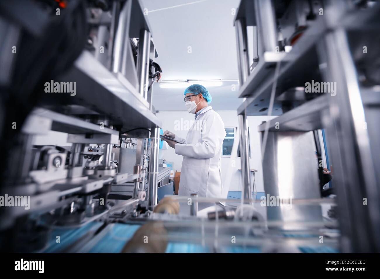 Quality control worker analyzing manufacturing machine in laboratory ...